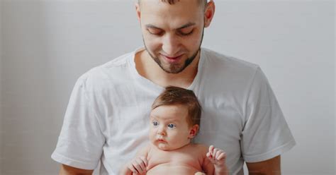 무릎을 꿇고 신생아를 안고 있는 행복한 백인 아버지 흔들리는 아이 딸 아들을 껴안고 있는 남자 부모 본격적인 라이프 스타일 솔직한 순간 자랑스러운 젊은 아빠 가족