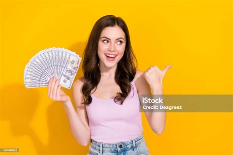 매력적인 쾌활한 사람의 사진 미국 지폐를 직접 엄지 손가락 빈 공간 노란색 배경에 고립 20 24세에 대한 스톡 사진 및 기타