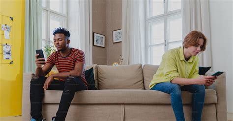 집에서 소파에 앉아 서로를 무시하는 스마트폰에 중독된 젊은 혼성 커플 관계 문제집에서 디지털 분할 스마트폰 및 노트북 사회 네트워크 개념을 사용하는 행복한 젊은 부부