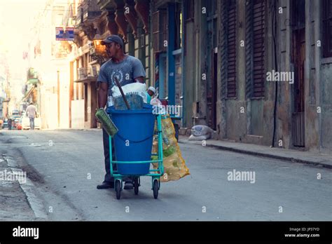 A Man Pushes A Trash Bin Collecting Garbage On The Streets Of Havana Cuba Stock Photo Alamy