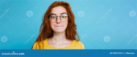 Headshot Portrait Of Happy Ginger Red Hair Girl With Funny Face Looking At Camera Pastel Blue