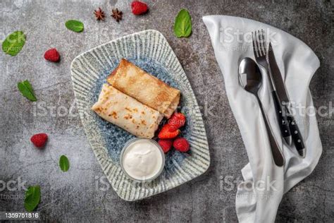 맛있는 아침 식사 냅킨과 칼붙이가 있는 회색 스톤 테이블에 새워 크림이 달린 흰색 접시에 딸기로 가득 찬 달콤한 팬케이크 0명에 대한 스톡 사진 및 기타 이미지 Istock