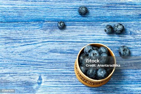 소박한 빈티지 테이블에 러시아 자작나무 나무 껍질 그릇에 갓 수확 한 육즙과 신선한 블루베리 빌 베리는 평면도 배경입니다 건강 한 식습관 항 산화 영양 개념입니다 복사 공간
