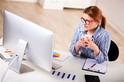 빨간 머리 여성사업가인 술마시기 커피 및 데스크톱 Pc를 사용하여 대한 기업 재무와 산업에 대한 스톡 사진 및 기타 이미지