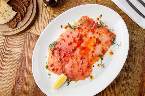 나무 배경에 흰색 접시에 빨간 캐비어와 연어 카르파치오의 상단보기 플랫 레이 음식 전통적인 이탈리아 쿠신 해산물 배경에 대한 음식 사진입니다 공간을 복사합니다 생선 0명에