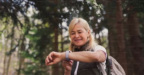 야외에서 스마트 워치를 사용하여 자연 속에서 숲을 걷는 노인 여성 등산객 사진 Unsplash의 슬로바키아 이미지