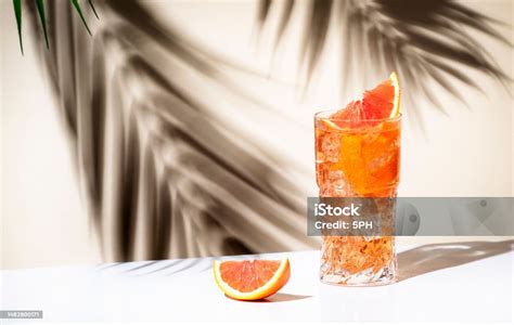 그랜드 Sazerac 알코올 칵테일 음료는 위스키 리큐어 쓴맛 압생트 프로 세코 하이볼 유리에 오렌지 풍미로 장식되어 있습니다 베이지색 배경 하드 라이트 그림자 패턴 건강