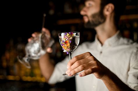 꽃으로 장식 된 유리에 칵테일을 제공하는 수염이있는 매력적인 바텐더 각얼음에 대한 스톡 사진 및 기타 이미지 각얼음 갈색