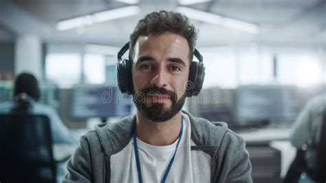 Office Portrait Of Happy It Programmer Wearing Headphones Working On