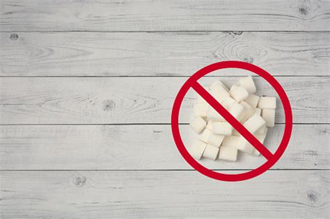 정제된 설탕 더미와 나무 배경에 슬래시가 있는 빨간 반지 설탕을 포기하는 개념과 설탕을 첨가하지 않은 영양 0명에 대한 스톡 사진 및 기타 이미지 Istock