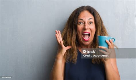 중세 스페인 여자 회색 그런 지 서 벽 마시는 한잔의 커피 매우 행복 하 고 흥분 상자 식 큰 웃음과 비명과 손을 승리를 축 하 갈색 머리에 대한 스톡 사진 및 기타 이미지