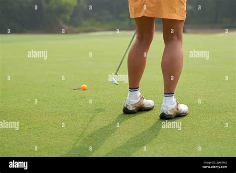Legs Of Woman Putting Golf Ball In The Hole Stock Photo Alamy