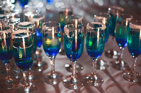 야외 이벤트 아름 다운 Bokeh와 그림에 장식 된 케이터링 꽃다발 테이블에 파티 마티니 보드카 그리고 다른 사람에 다른 색된 알코올 칵테일의 아름 다운 행 선 결혼식에