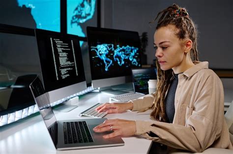 Premium Photo Young Serious Female Programmer Using Laptop By Workplace In Office