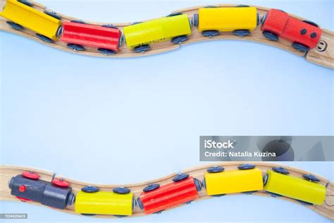 파란색 배경에 나무 철도에 여러 가지 빛깔의 아이 기차 자동차 벽돌로 만든 텍스트 프레임 복사 합니다 평면도 평평한 누워 테이블에 어린이 장난감 0명에 대한 스톡 사진 및