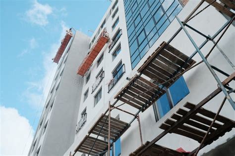 empty scaffolding near the building with spread out work items ropes buckets uniforms and a