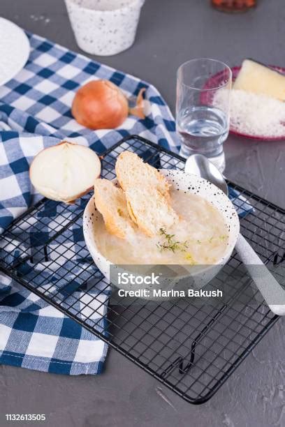 회색 돌 배경에 흰색 컵에 치즈와 크루 톤 양파 수프 밝은 색상의 전통적인 프랑스 수프 국가 음식입니다 텍스트를 위한 여유 공간