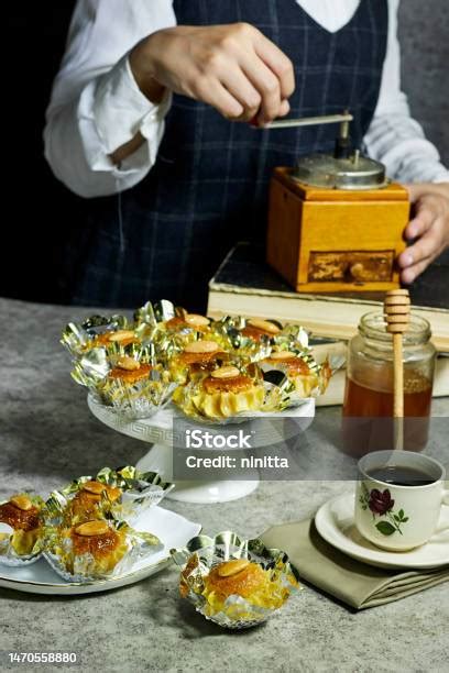 아랍어로 Dziriettes라는 이름의 동양 알제리 달콤한 쿠키와 꿀 항아리 데이지 꽃과 수동 커피 그라인더를 사용하는 여자