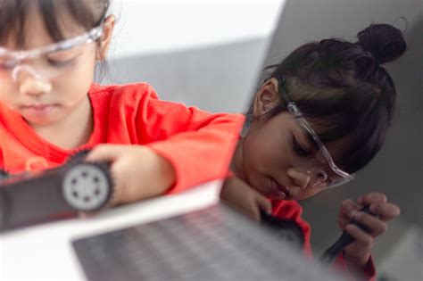 아시아 학생들은 집에서 Stem Steam 수학 공학 과학 기술 컴퓨터 코드 아이들을위한 로봇 공학 개념의 로봇 자동차 및 전자