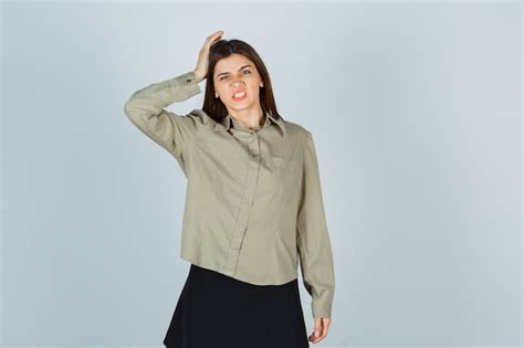 Hembra Joven Manteniendo La Mano En La Cabeza En Camisa Falda Y