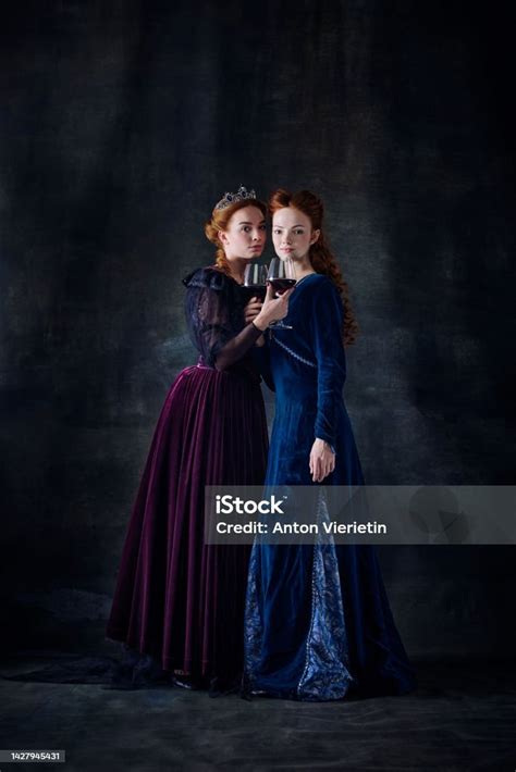 어두운 배경에 고립 된 와인 잔을 가진 여왕의 이미지에있는 두 명의 아름다운 여성의 초상화 축하 20 24세에 대한 스톡 사진 및 기타 이미지 Istock
