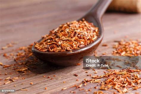 루이보스 티의 세라믹 숟가락에 위치 해 있습니다 차 클로즈업 매크로 사진입니다 꽃잎 차 나무 보드에 숟가락에 있습니다 루이보스 티의 천연 성분입니다 0명에 대한 스톡 사진