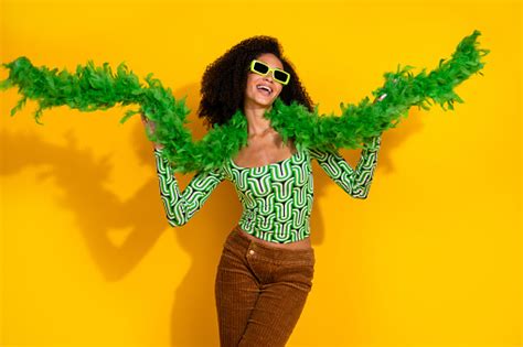노란색 배경에 깃털 보아를 들고 녹색 상단에 곱슬 머리를 가진 젊은 아프리카 계 미국인 여성 깃털에 대한 스톡 사진 및 기타 이미지 Istock