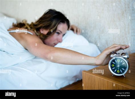 Woman Reaching To Turn Off Her Alarm Clock Stock Photo Alamy