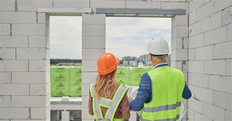 금발 여자 옆에 서 있는 그의 손에 집 계획을 가진 남자의 뒷모습 사진 Unsplash의 건축 계약자 이미지