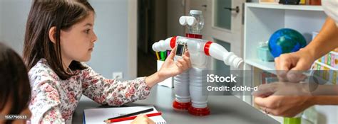 Siswa Perempuan Memegang Panel Surya Di Atas Robot Mainan Daur Ulang Di