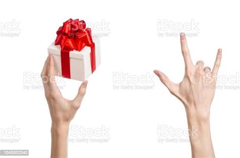 축 하와 선물의 테마 화이트 레드 리본 및 활 스튜디오에서 흰색 배경에 고립 된 가장 아름 다운 선물 상자에 포장 하는 선물을 들고 손 기념일에 대한 스톡 사진 및 기타
