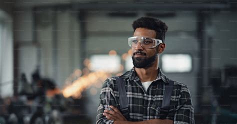 금속 작업장에서 실내에서 팔짱을 끼고 서 있는 젊은 산업 남성의 초상화 사진 Unsplash의 슬로바키아 이미지