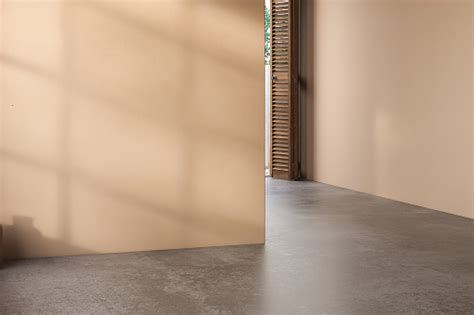 베이지색 벽 콘크리트 바닥 벽에 드리워진 창틀의 그림자가 있는 넓고 빈 방입니다 뒷마당의 전망은 공간에 차분함과 평온함을 더해줍니다 3d 렌더링 0명에 대한 스톡 사진 및