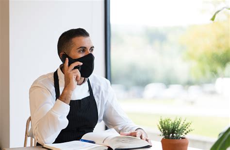 코로나바이러스 전염병 중 보호 마스크 유니폼 앞치마를 입고 레스토랑에서 전화로 예약 및 배달을 확인하는 셰프 30 34세에 대한 스톡 사진 및 기타 이미지 Istock