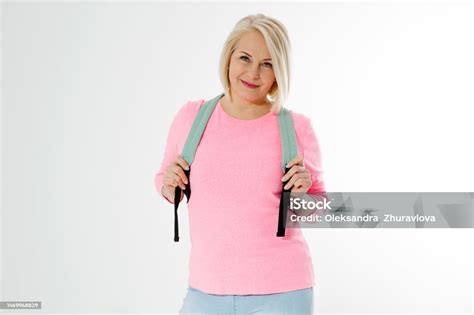 흰색 배경에 고립된 배낭을 멘 스포티한 행복한 중년의 아름다운 여성 공간을 복사합니다 중년 여성의 건강한 라이프 스타일 폐경기 활동적인 삶 여자는 운동하러 간다 건강한 노인