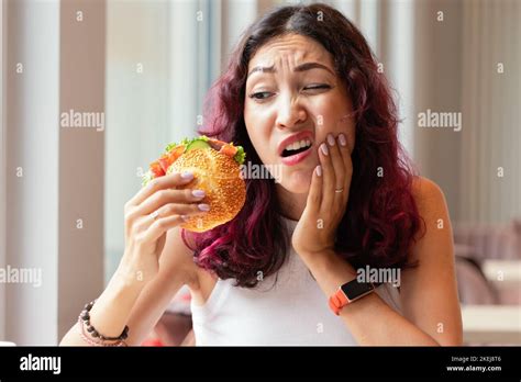 Mujer Comiendo Una Hamburguesa En Un Café De Comida Rápida Y Sintió Un Fuerte Dolor En La Boca