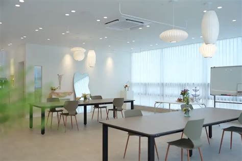 깔끔한 스타일의 곡선형 팬던트 조명과 넓은 책상이 있는 플로리스트 학원 강의 공간 사진