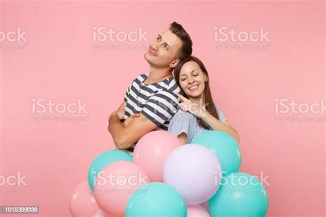 사랑 서 다시 뒤에에서 한 쌍의 초상화 여자와 남자 생일 휴가 축 하 하는 파란색 옷에 화려한 공기 풍선 파스텔 핑크 배경에 파티 사람들이 진심으 감정 개념 공휴일에 대한