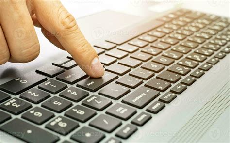 Close Up Of Human Finger Pressing Enter Key On Laptop Keyboard