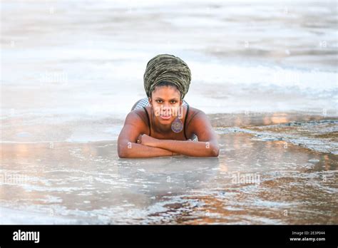 Beautiful Girl Enjoying Winter And Lying On The Ice In The Cold Water Of A Lake Or River Cold