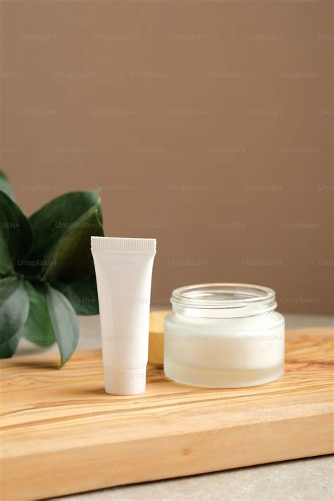 흰색 화장품 로션 튜브와 녹색 잎이 있는 나무 보드에 보습 크림 항아리 세트 천연 허브 스파 미용 제품 포장 디자인 브랜딩 사진 Unsplash의 포장 이미지