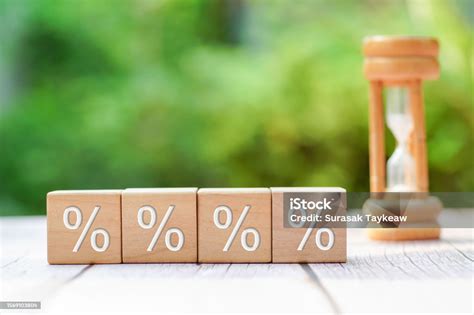 나무 테이블과 자연 배경에 모래시계가 있는 나무 큐브에 퍼센트 기호 사업 및 금융 할인 이자율 성장하는 사업 소득 개념 투자 수익 예금 소득 가격에 대한 스톡 사진 및 기타