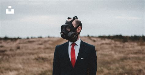 낮에 갈색 들판에 서 있는 검은 양복을 입은 남자 사진 Unsplash의 무료 의류 이미지