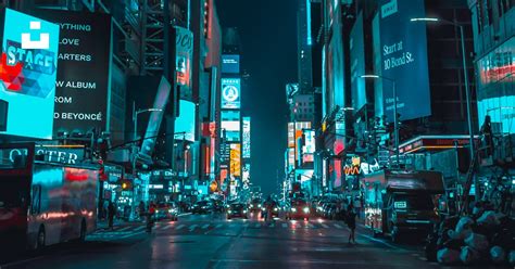 야간에 대형 건물 사이의 도로를 주행하는 차량의 거리 사진 사진 Unsplash의 무료 타임스 스퀘어 이미지