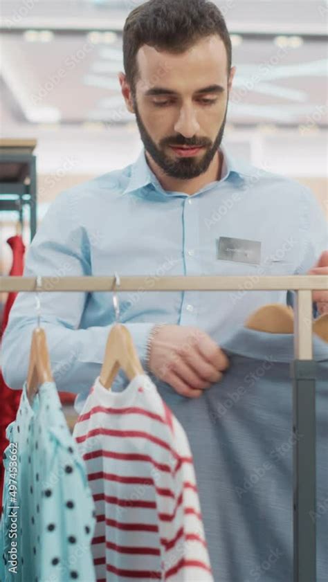 Vertical Portrait Of A Handsome Male Clothing Store Assistant Working