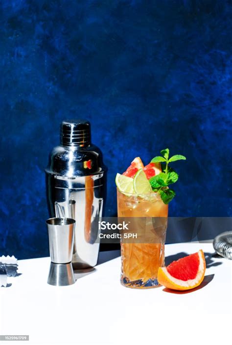 화이트 럼 라임 주스 자몽 슬라이스 민트 얼음을 곁들인 좀비 칵테일 음료 파란색과 흰색 배경 바 도구 하드 라이트 그림자 패턴 0명에 대한 스톡 사진 및 기타 이미지