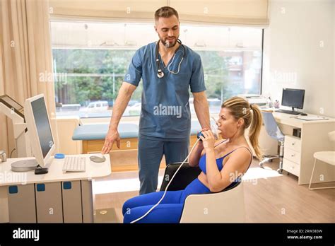 Male Dietologist Watching Woman Taking Resting Metabolic Rate Test