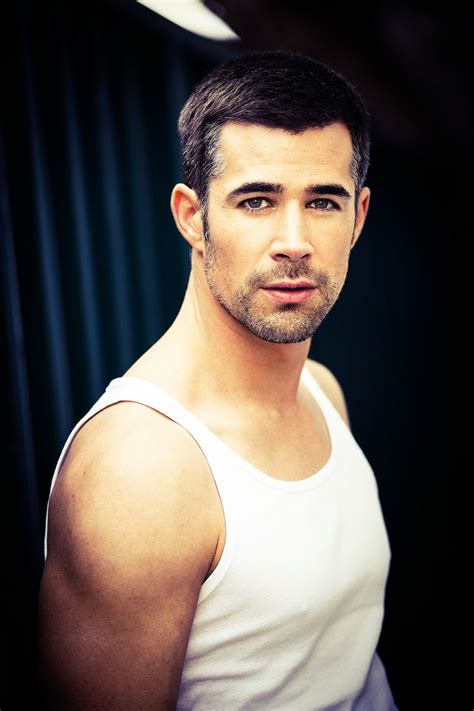 A Man In White Tank Top Looking At The Camera