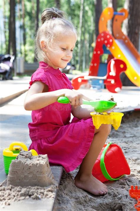 Маленькая девочка играя на ящике с песком Стоковое Фото изображение насчитывающей счастливо