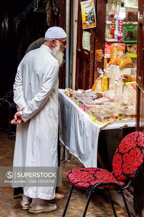A Man And His Wife Buying Sweets And Candy From A Shop In The Medina